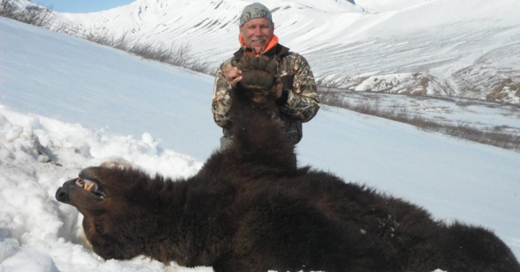 This Man Posed Proudly With the Bear he Shot While it Was Hibernating